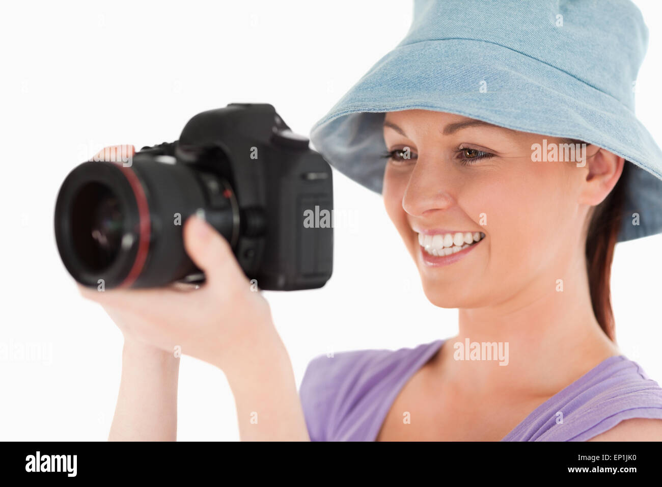 Cute female using a camera while standing Stock Photo - Alamy