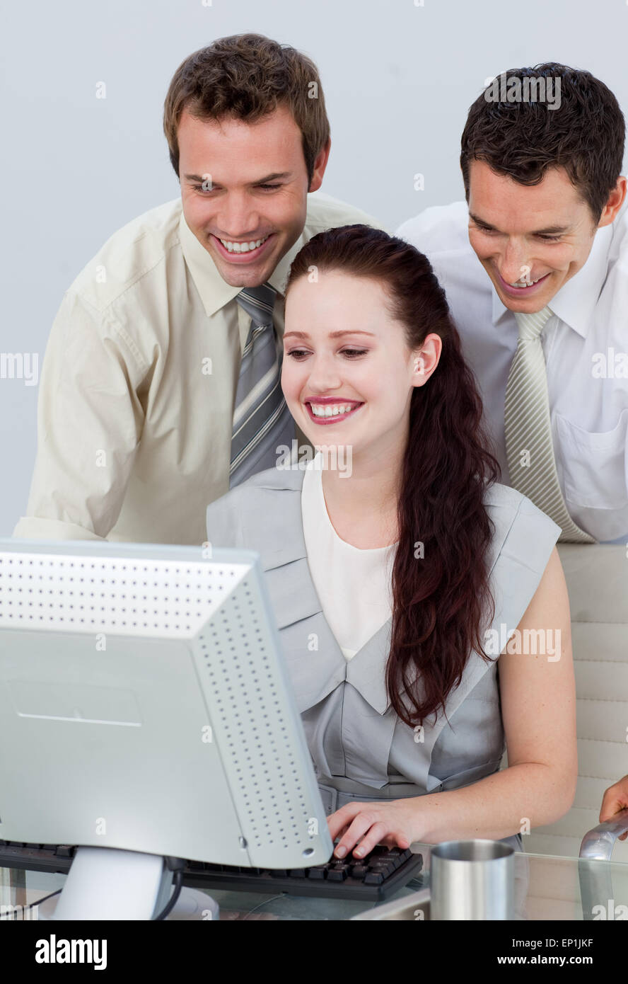 Businessmen helping her colleague with a computer Stock Photo - Alamy