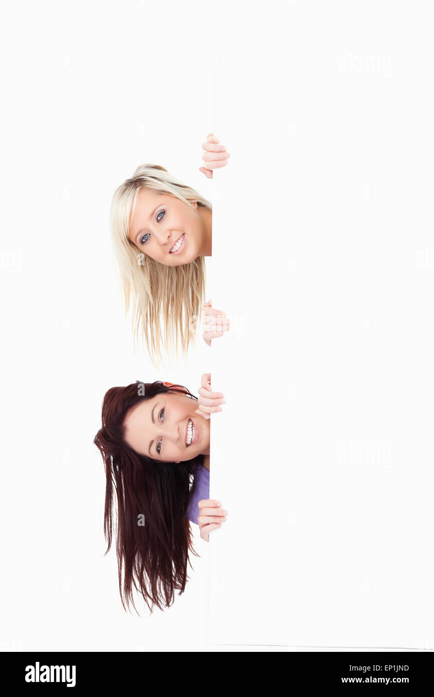 Charming Women peeking around a banner Stock Photo - Alamy