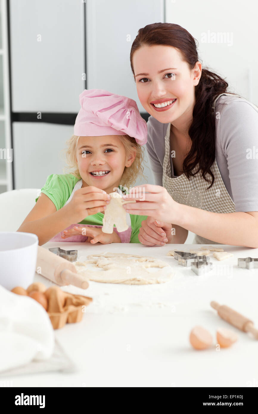 Happy girl with her mother baking little cakes Stock Photo - Alamy