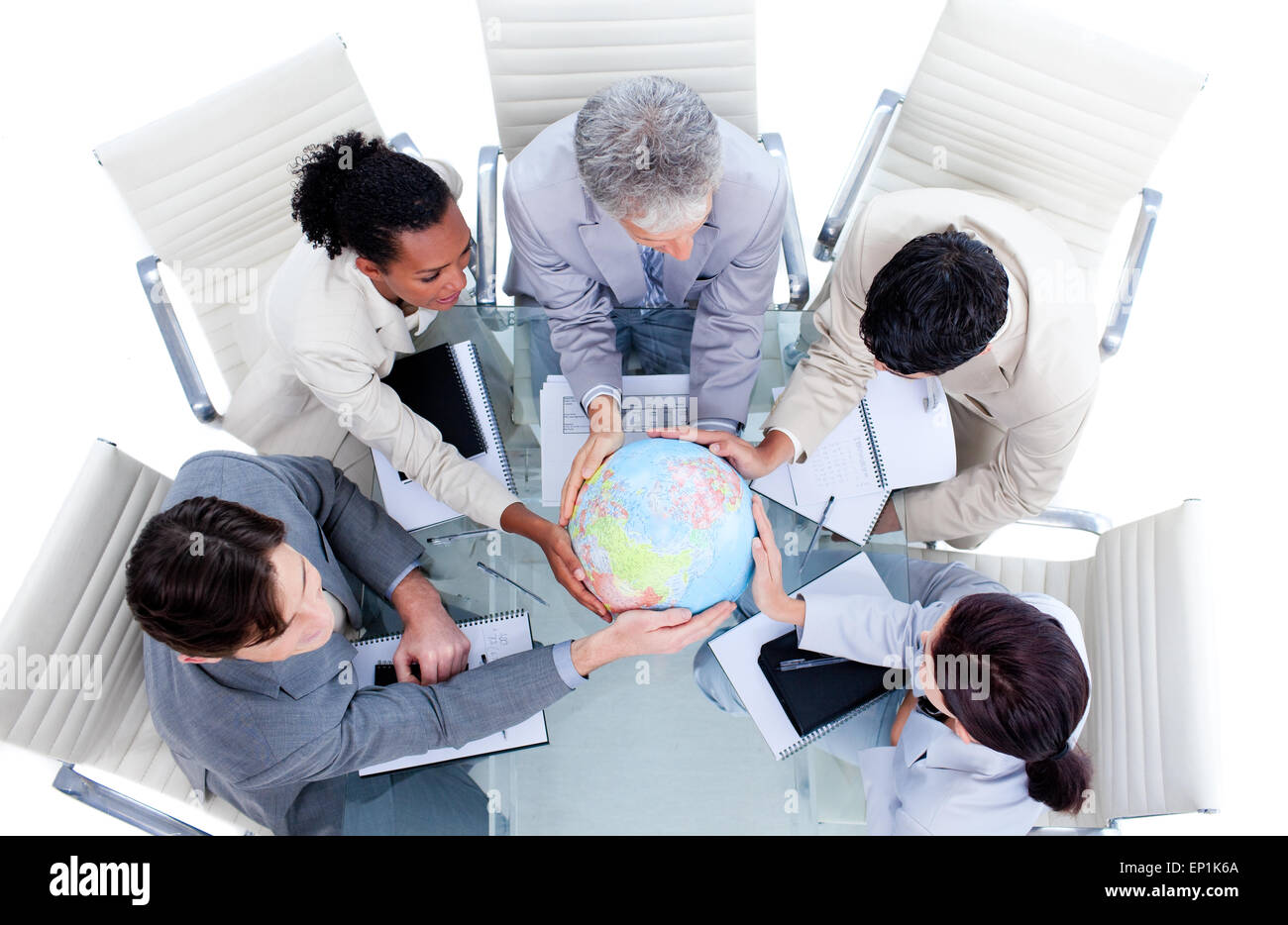 Serious international business team holding a terrestrial globe in a ...