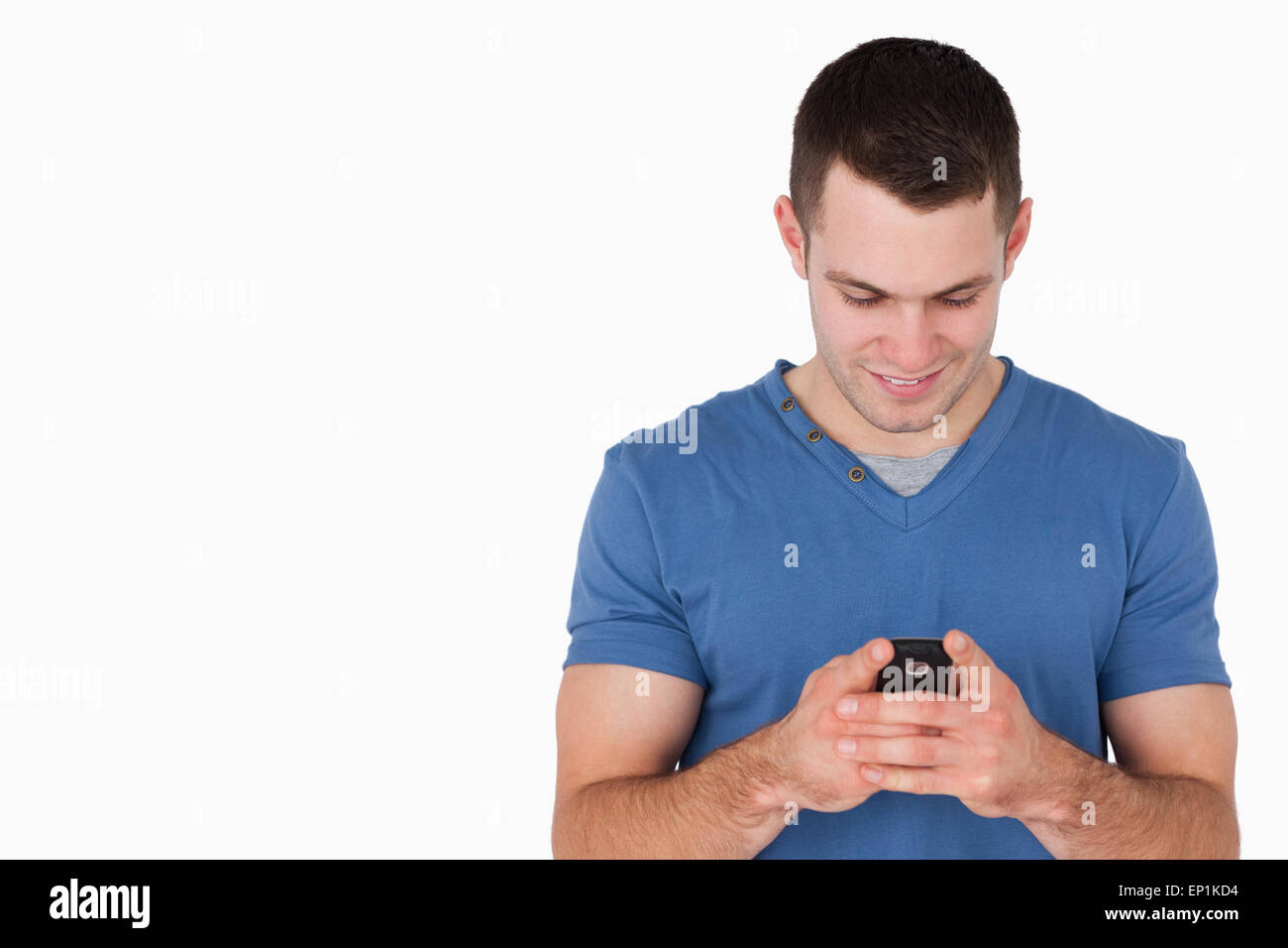 Smiling man sending text messages Stock Photo - Alamy