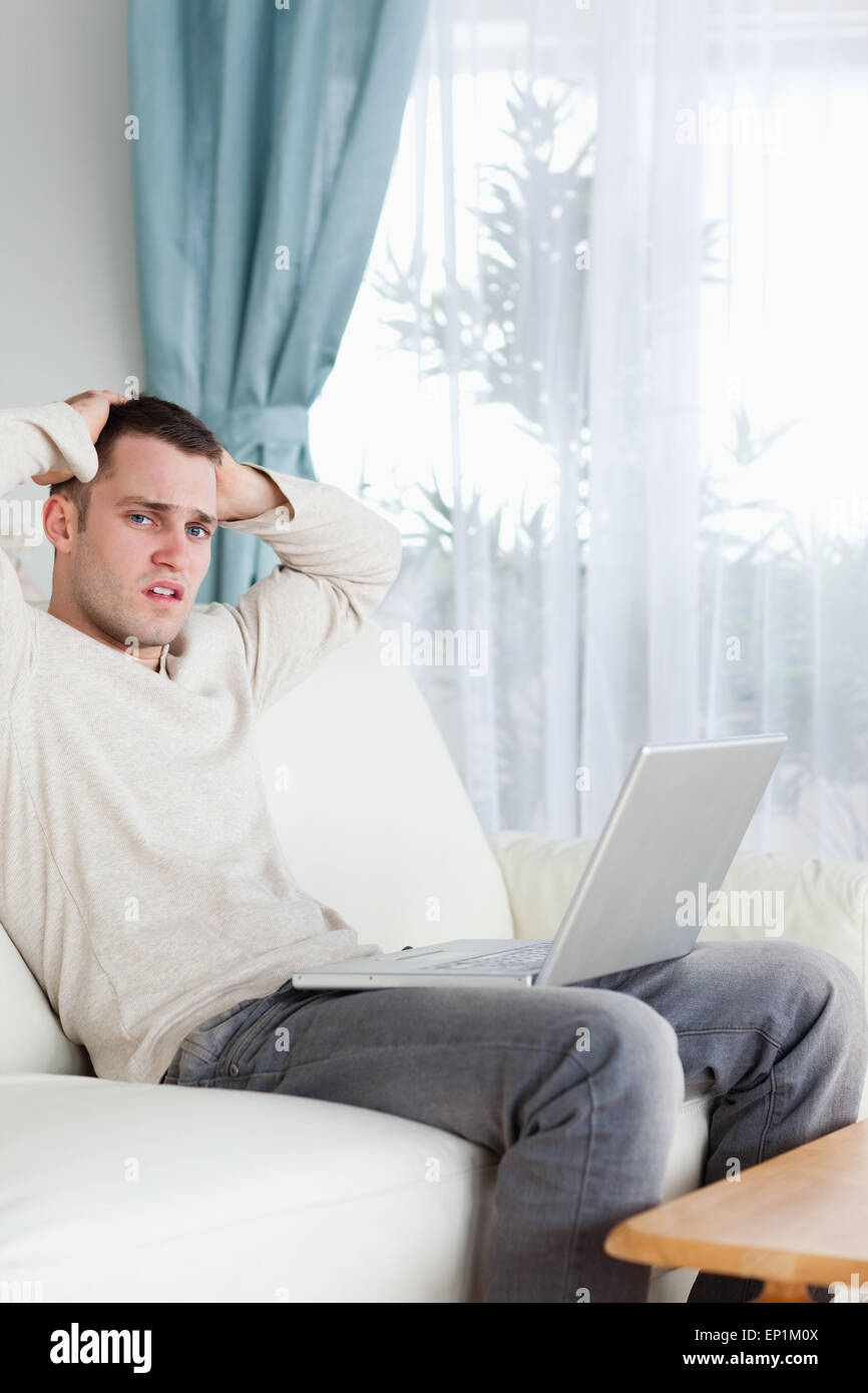 Portrait of a sad man working with his laptop Stock Photo - Alamy