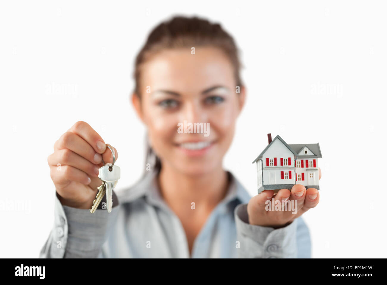 Keys and miniature house being presented by female estate agent Stock ...