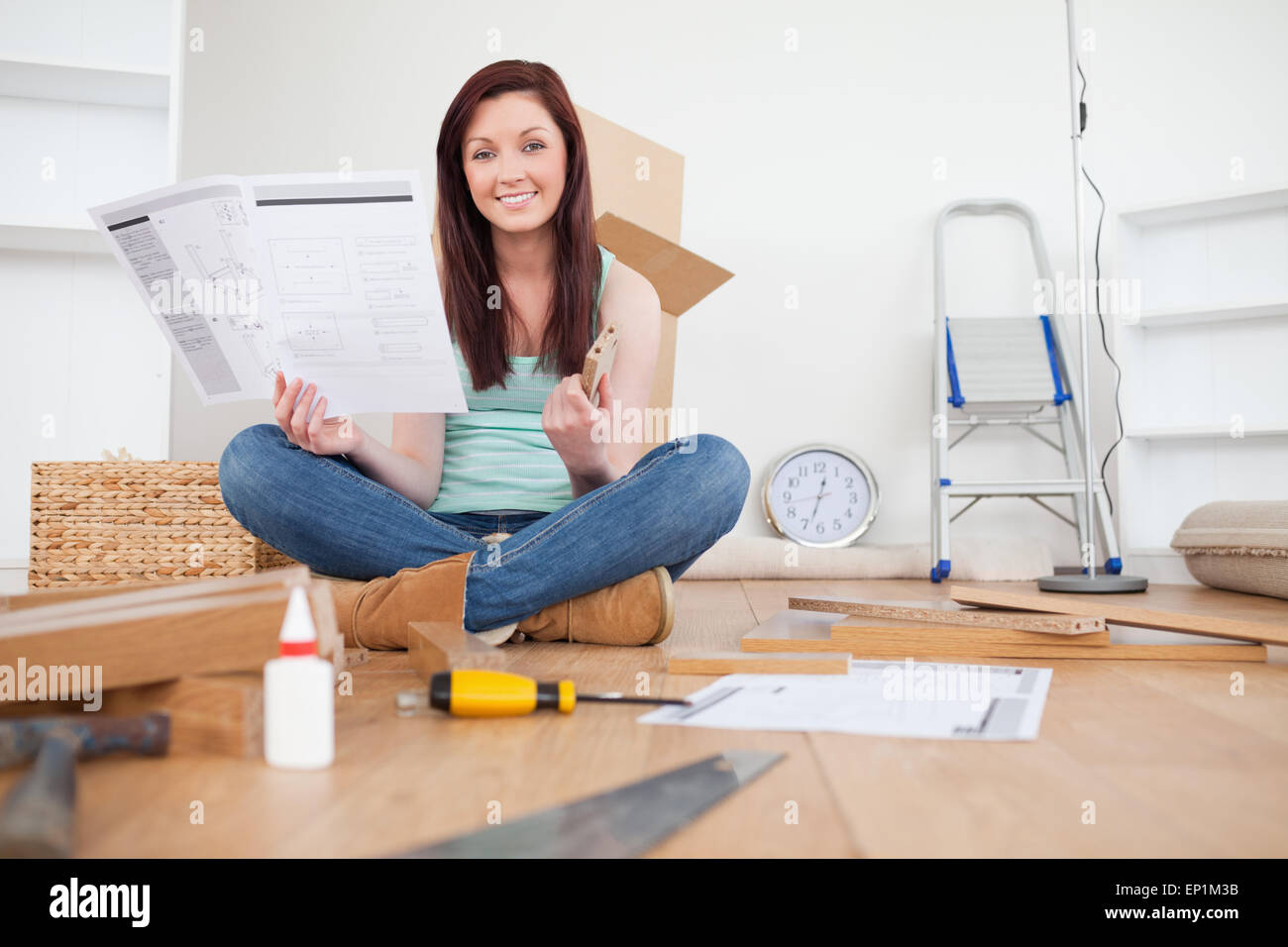 Happy beautiful red-haired female reading a manual before do-it ...