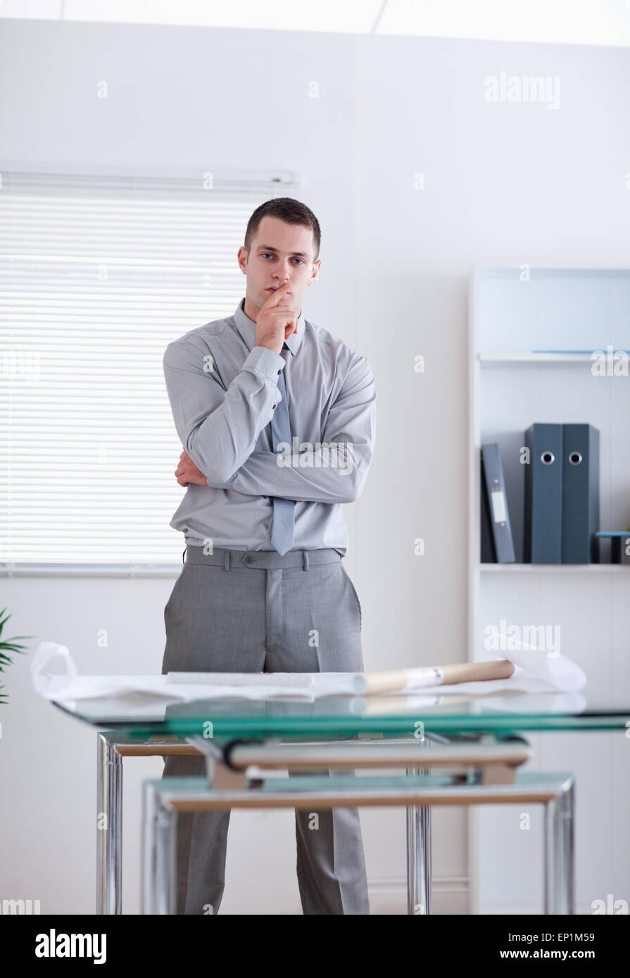 Businessman standing behind table Stock Photo - Alamy
