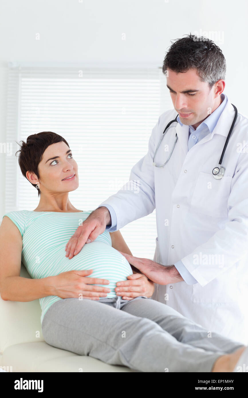 Doctor examining a pregnant woman's tummy Stock Photo - Alamy