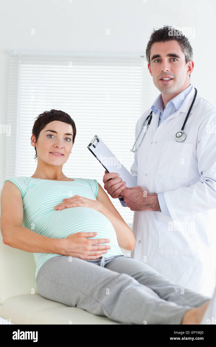 Doctor and pregnant patient looking at the camera Stock Photo - Alamy