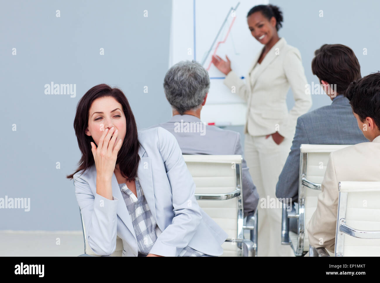 Bored businesswoman yawming at a presentation Stock Photo - Alamy