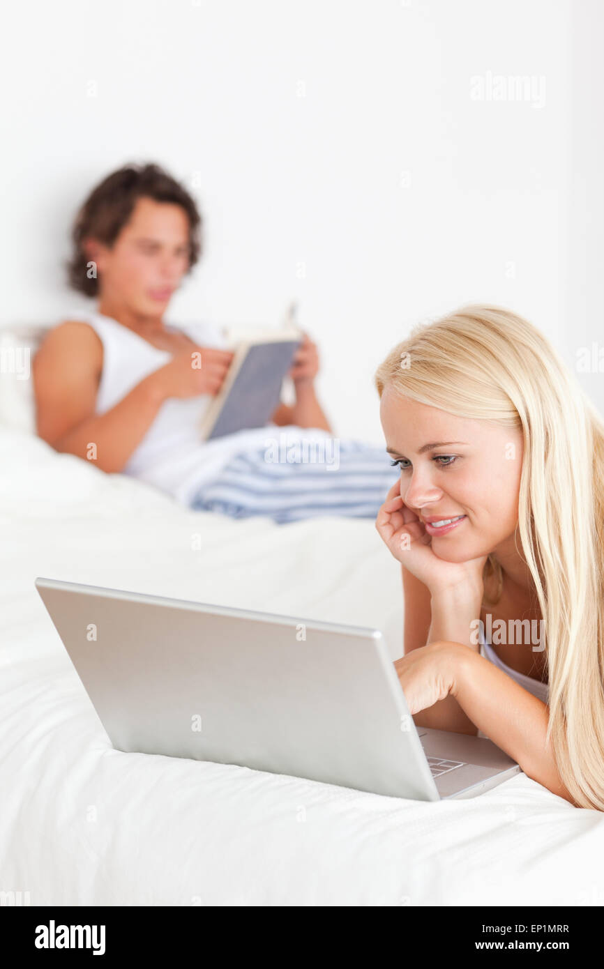 Portrait of a woman using a notebook while her fiance is reading Stock ...