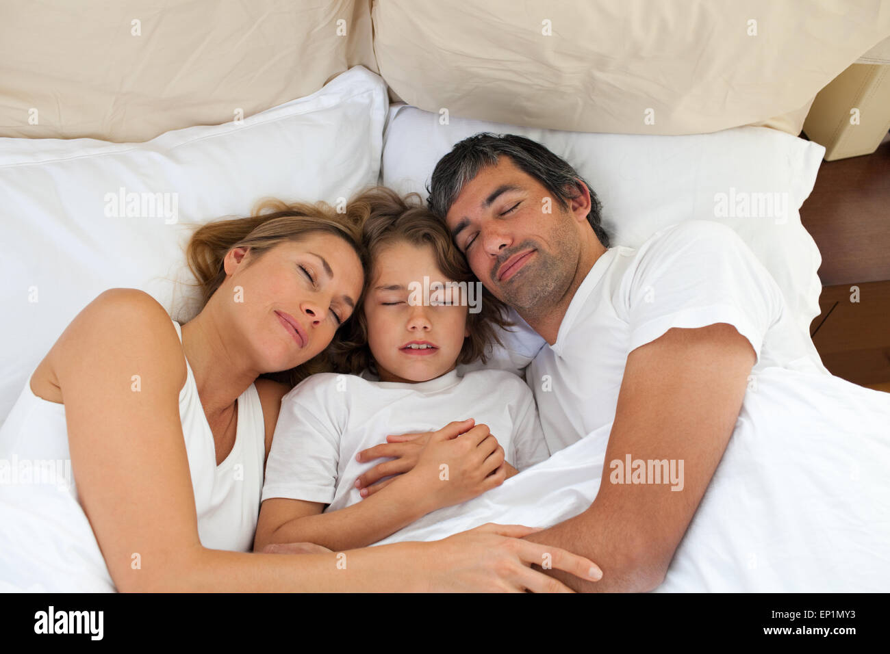Cute child and his parents sleeping together Stock Photo - Alamy