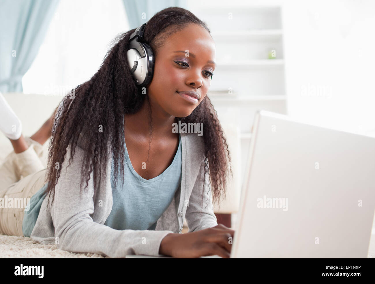 Close up of woman lying on the floor with her notebook enjoying Stock ...