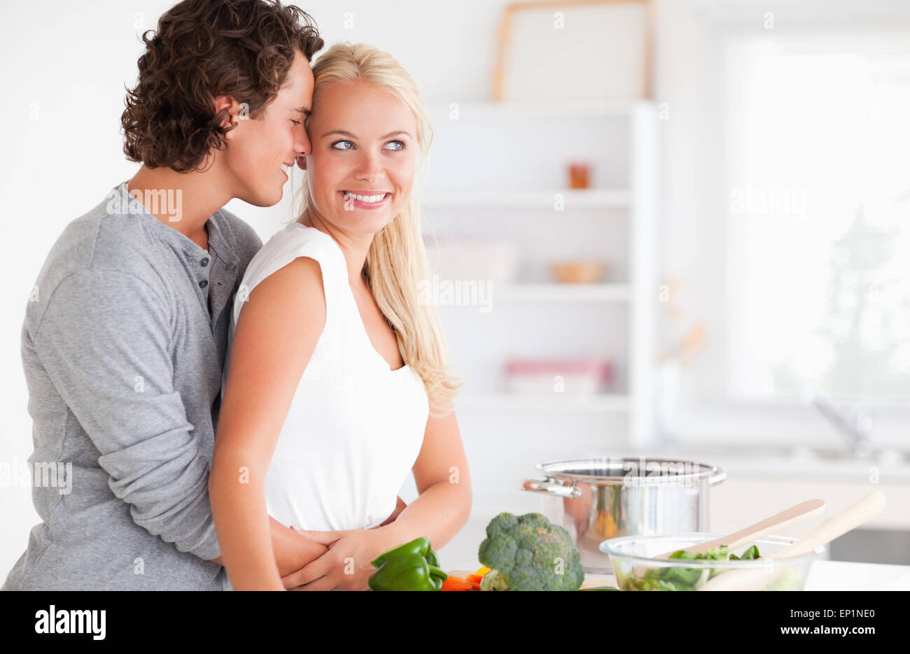 Couple hugging while cooking Stock Photo - Alamy