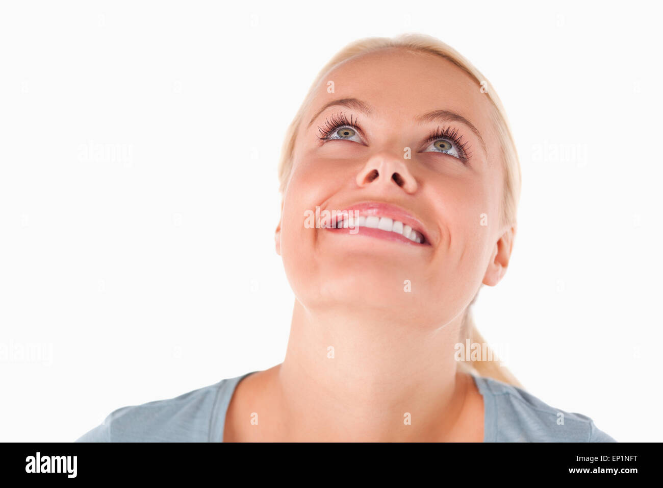 Smiling blond woman looking at the ceiling Stock Photo - Alamy