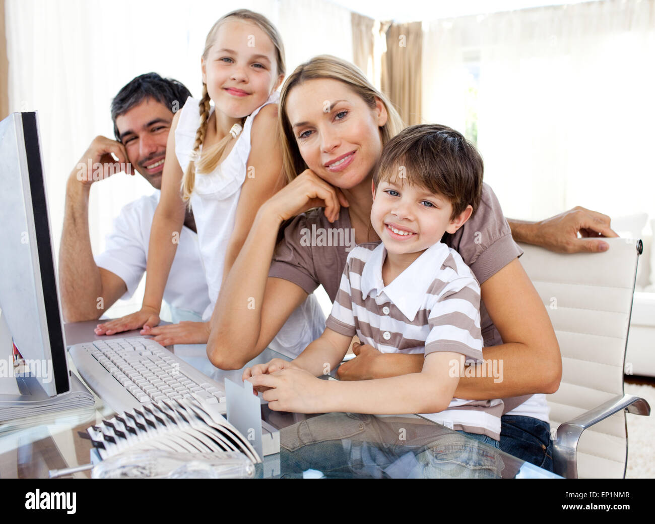 Attentive parents and their children using a computer Stock Photo - Alamy