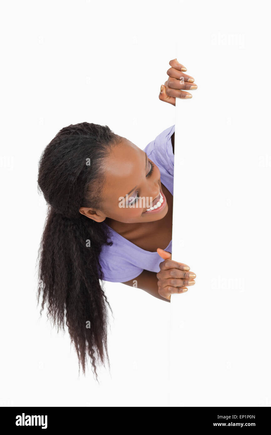 Young woman looking around the corner on white background Stock Photo ...