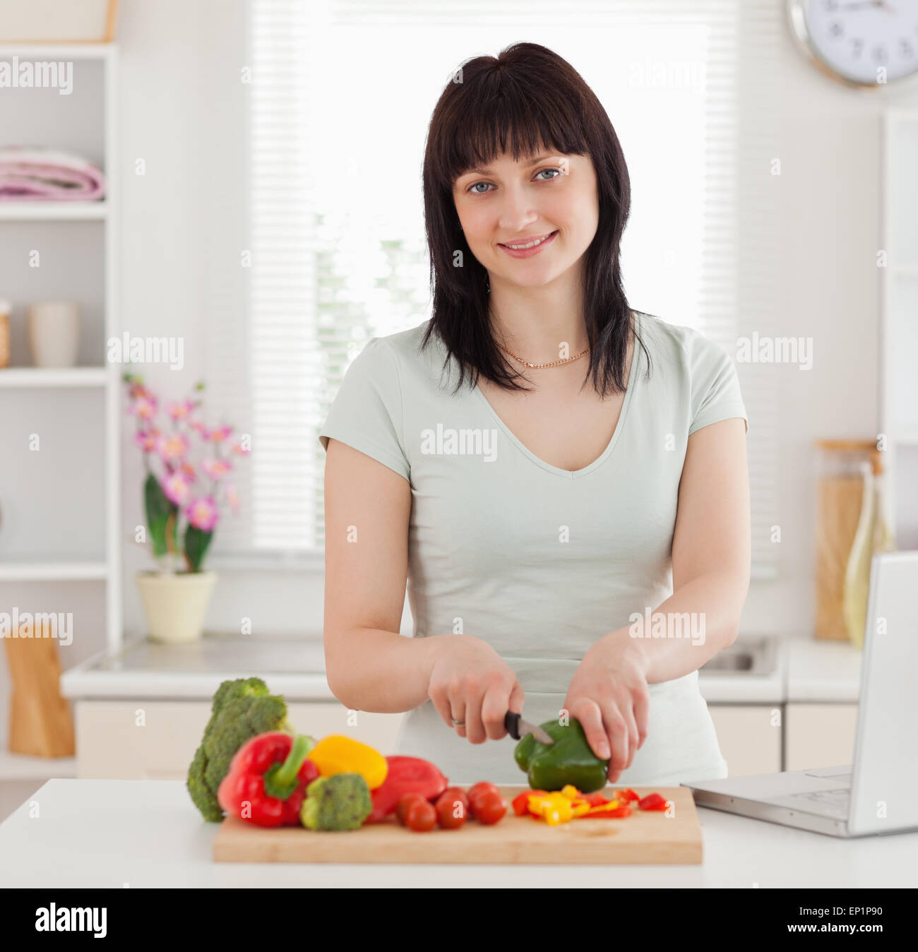 Pretty brunette woman cooking while relaxing with her laptop Stock ...