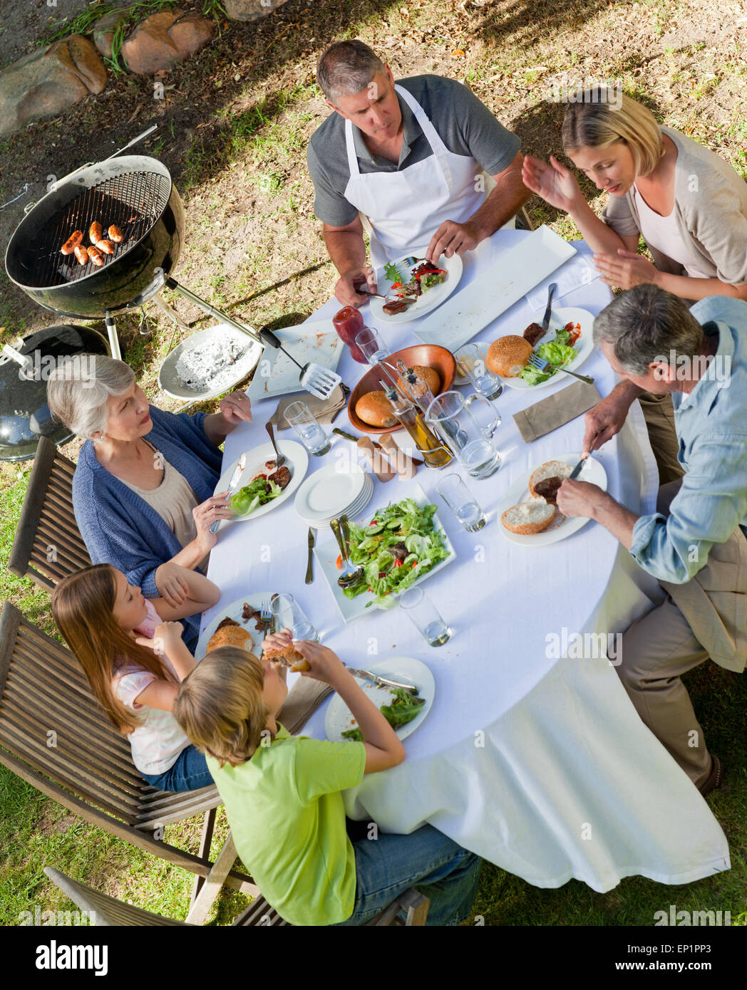 Adorable family eating in the garden Stock Photo - Alamy