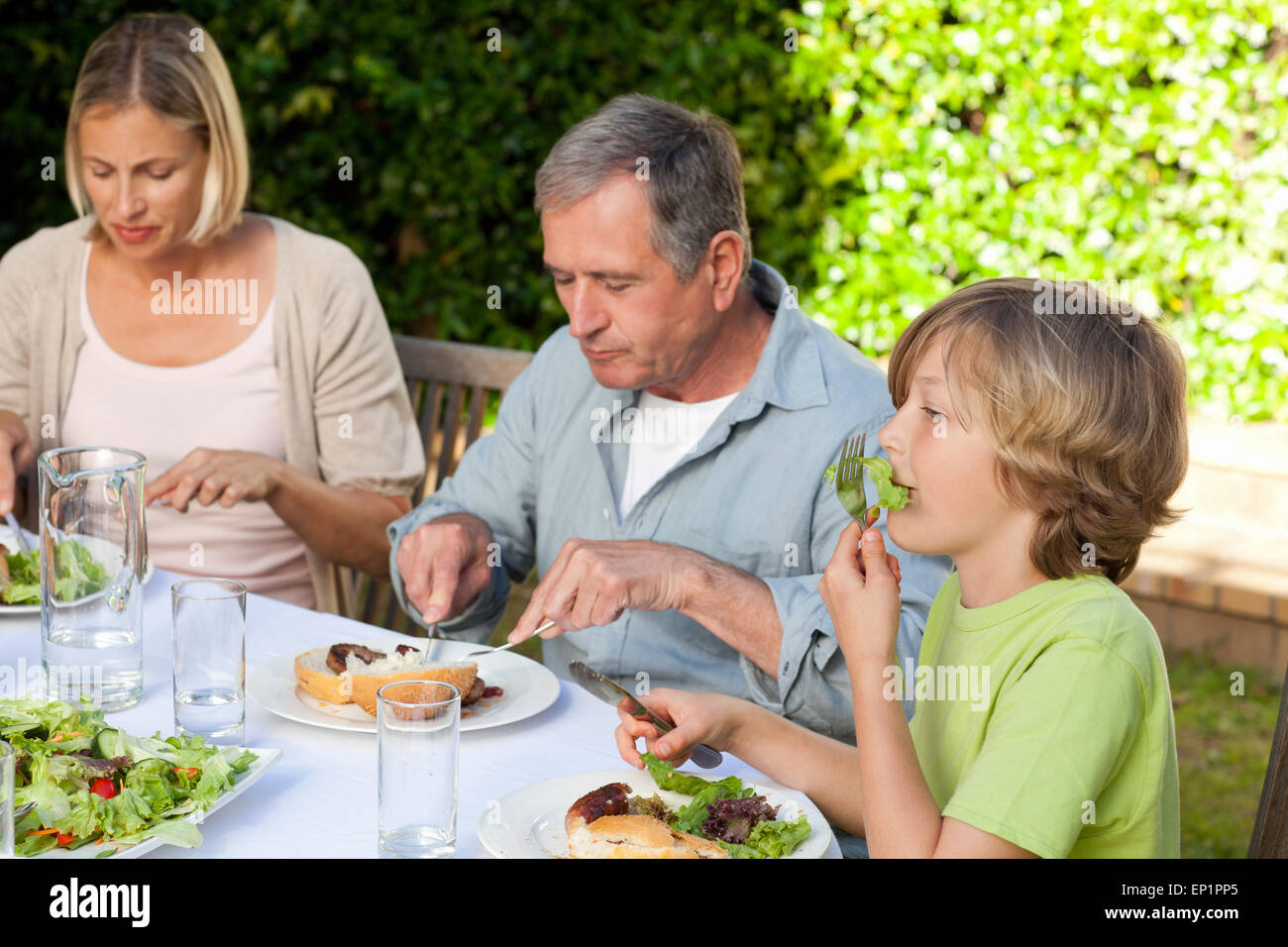 Adorable family eating in the garden Stock Photo - Alamy