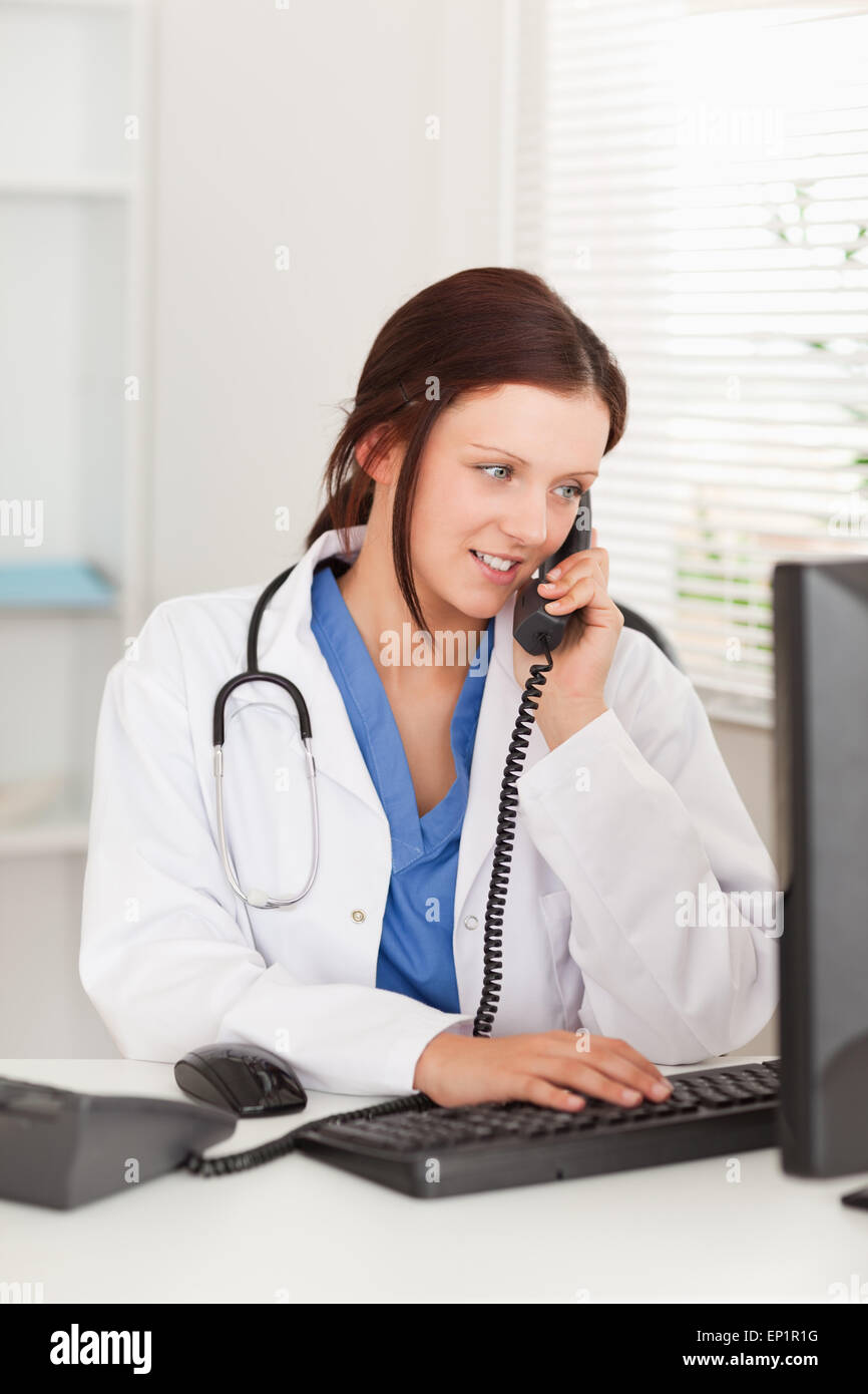 Female doctor telephoning by pc Stock Photo - Alamy