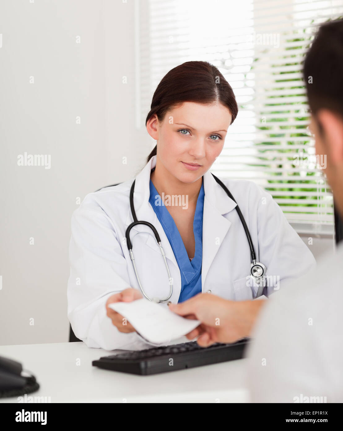 Kind female doctor giving patient prescription Stock Photo - Alamy