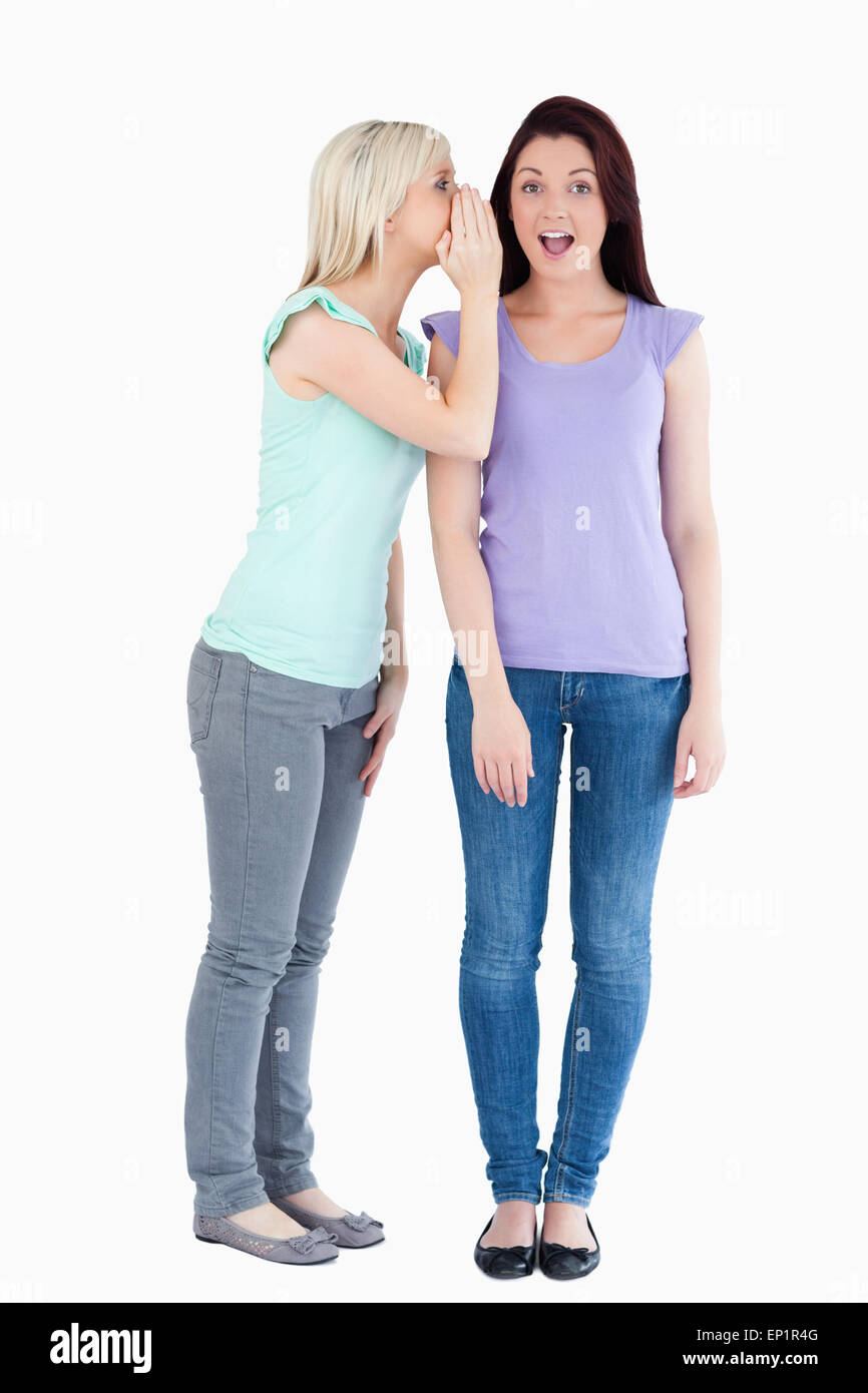 Gorgeous woman telling her friend a secret Stock Photo - Alamy