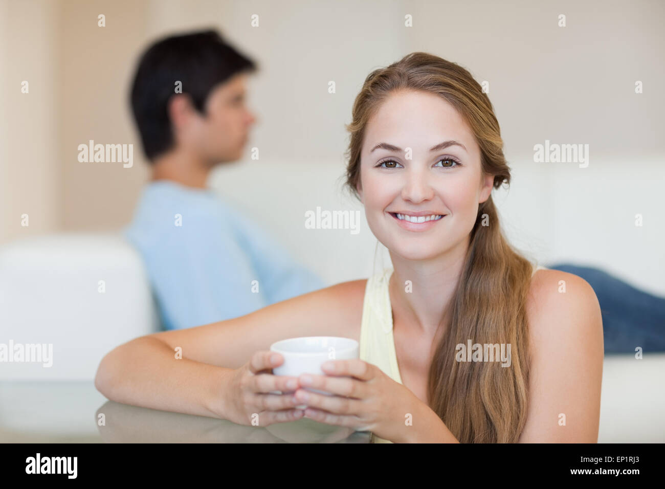Woman drinking tea while her fiance is sitting on a couch Stock Photo ...