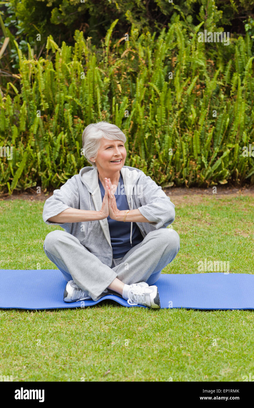 Retired woman practicing yoga in the garden Stock Photo - Alamy