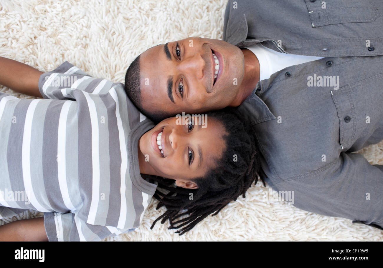 Smiling Afro-American father and son relaxing on the floor Stock Photo ...