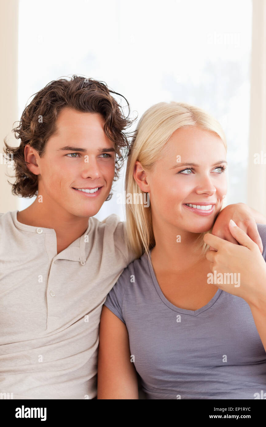 Portrait of a cute couple sitting on a couch Stock Photo - Alamy