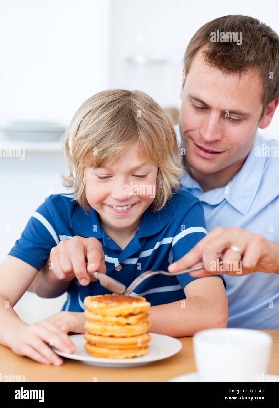 Attentive father and his son eating waffles Stock Photo - Alamy