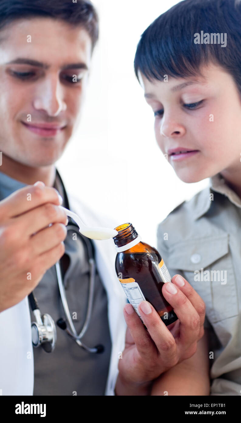 Assertive doctor giving medicine to a little boy Stock Photo - Alamy