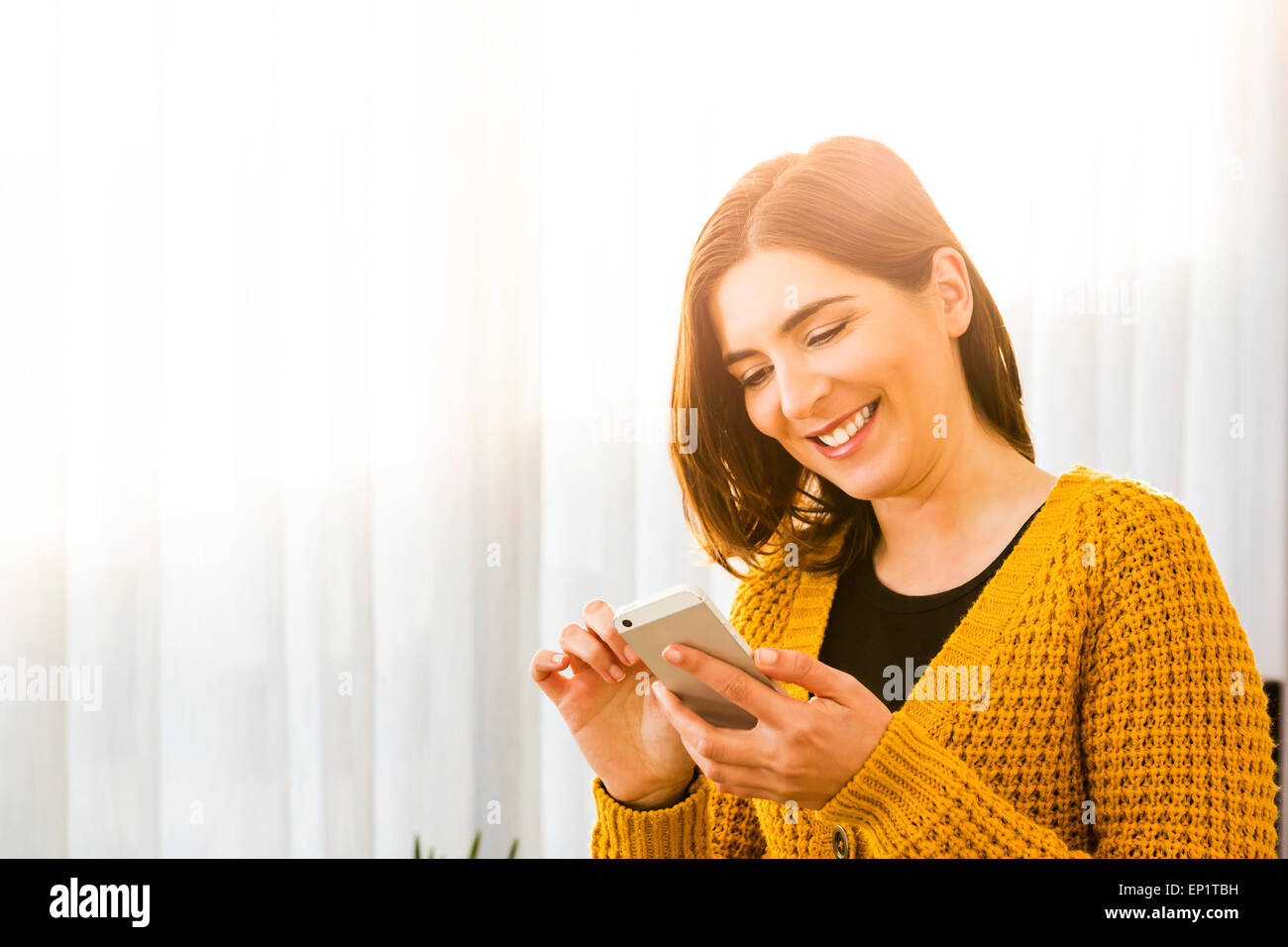 Beautiful young woman at home texting a message Stock Photo - Alamy