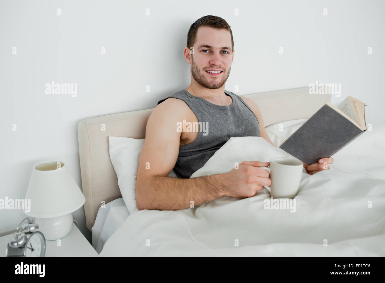 Young man reading a novel while drinking a coffee Stock Photo - Alamy