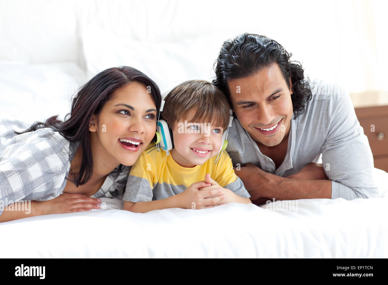 Happy parents listening to music with their son Stock Photo - Alamy