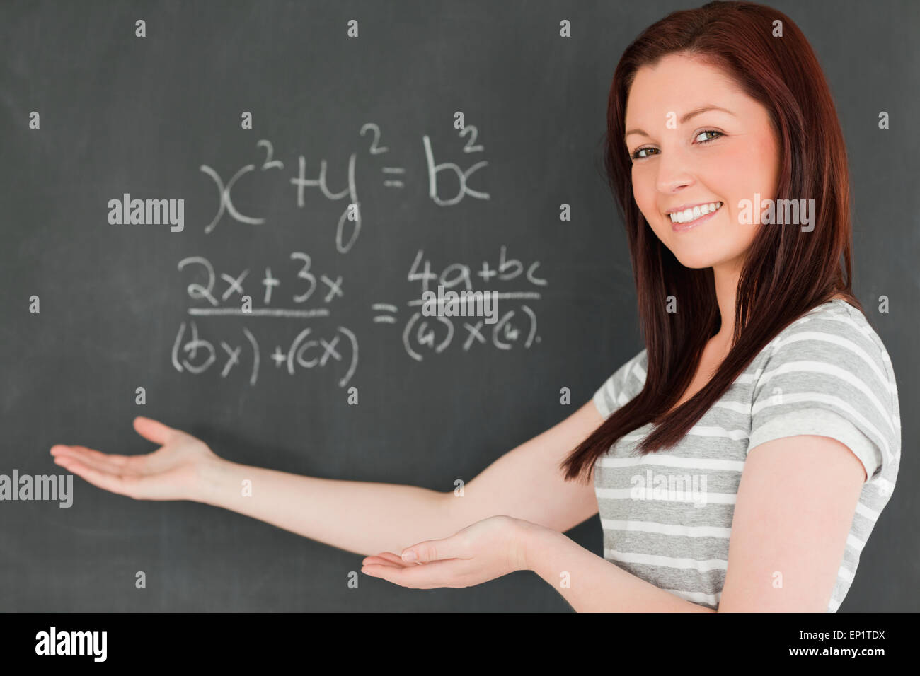 Beautiful young woman showing an equation on a blackboard Stock Photo ...