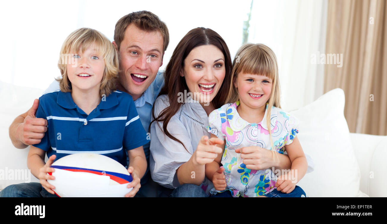 Happy family watching a rugby match Stock Photo - Alamy