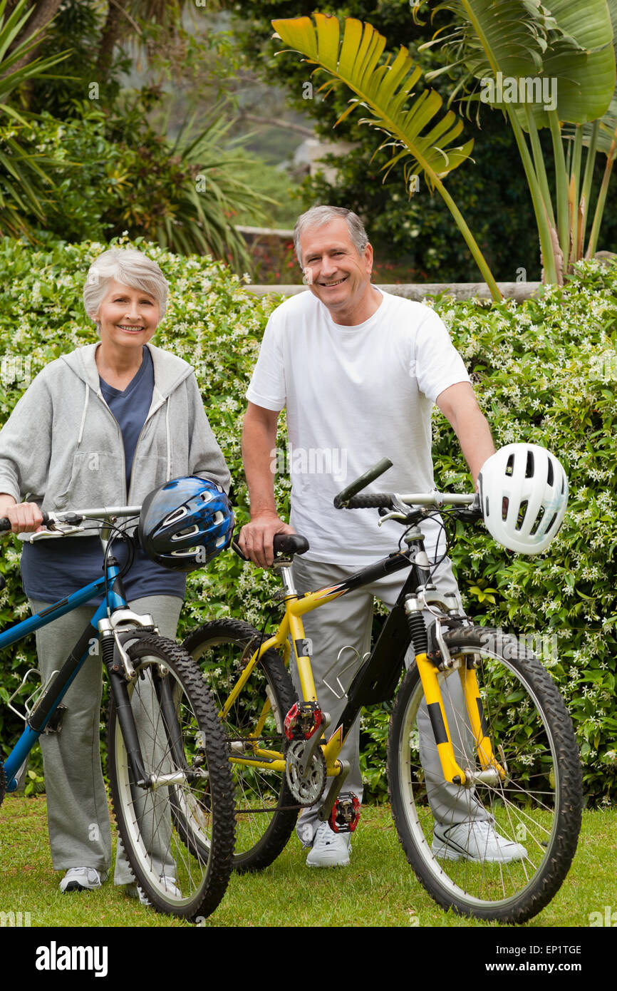 Mature couple walking with their bikes Stock Photo - Alamy