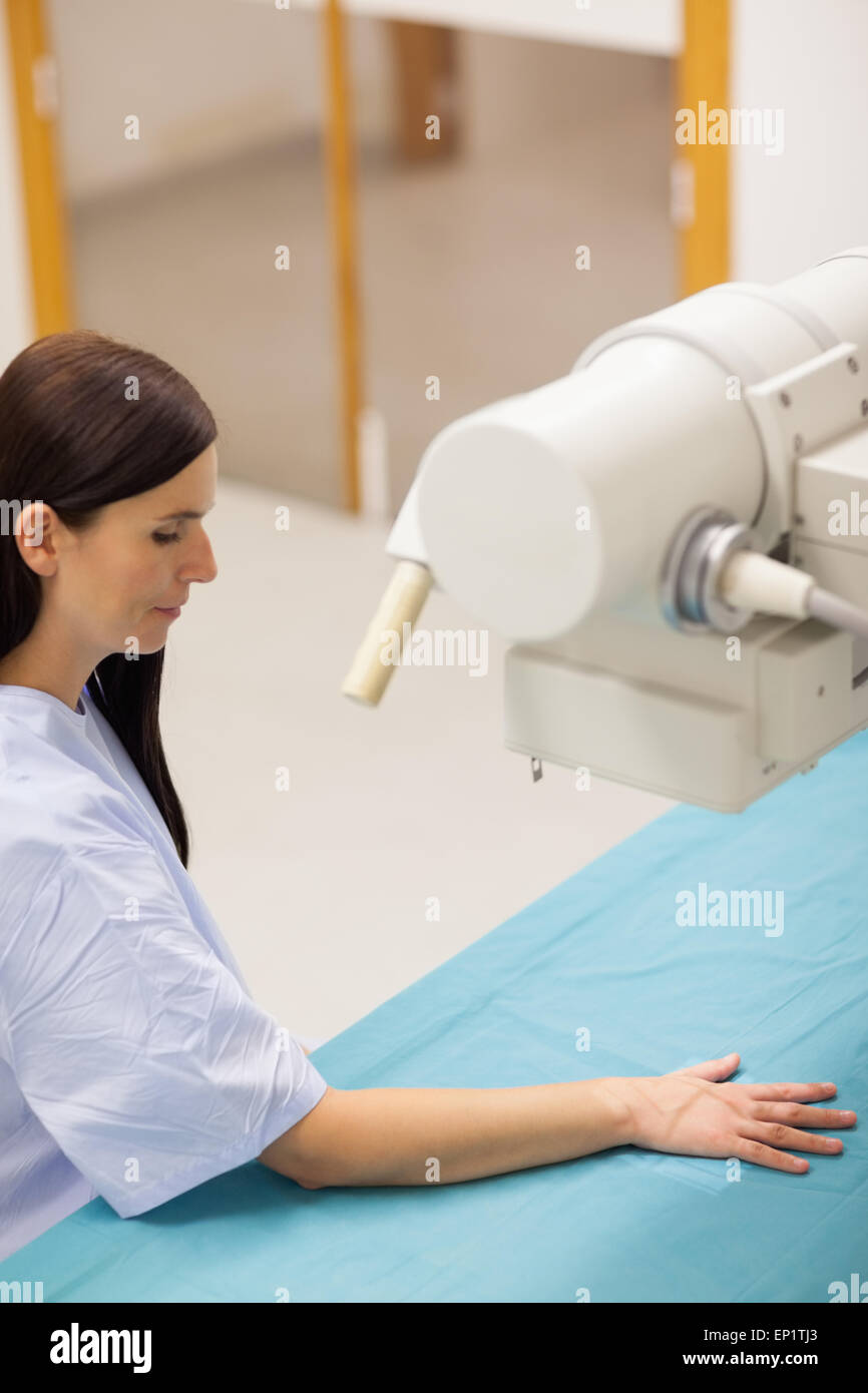 Woman positioning her arm on a medical table Stock Photo - Alamy