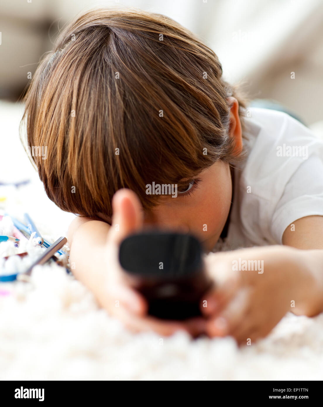 Cute little boy watching TV lying on the floor Stock Photo - Alamy