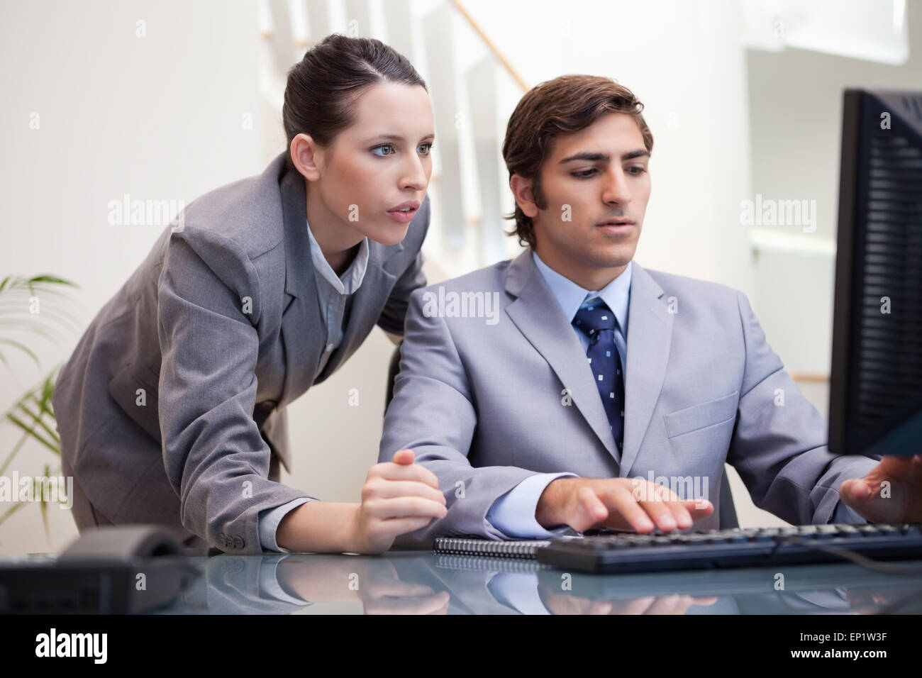 Business team looking at computer screen together Stock Photo - Alamy