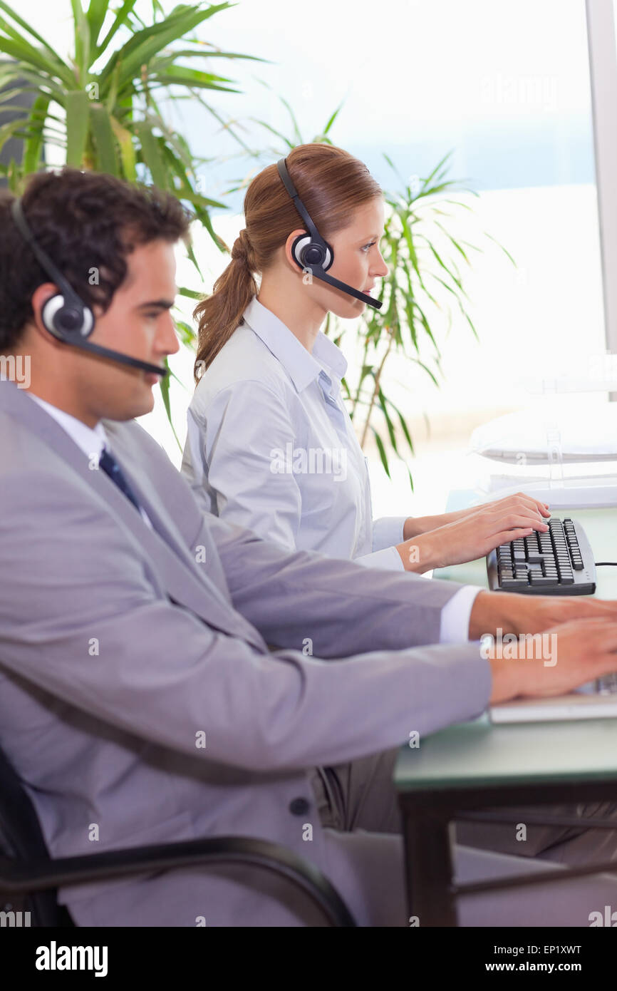 Call center agents working next to each other Stock Photo - Alamy