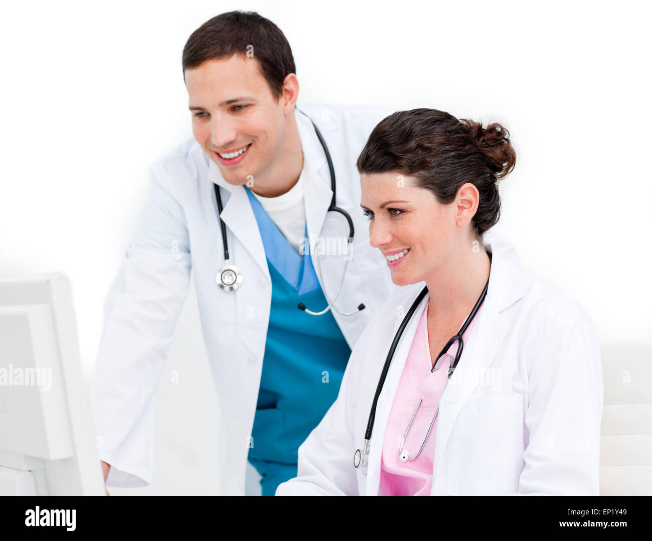 Cheerful medical team working at a computer against a white background ...