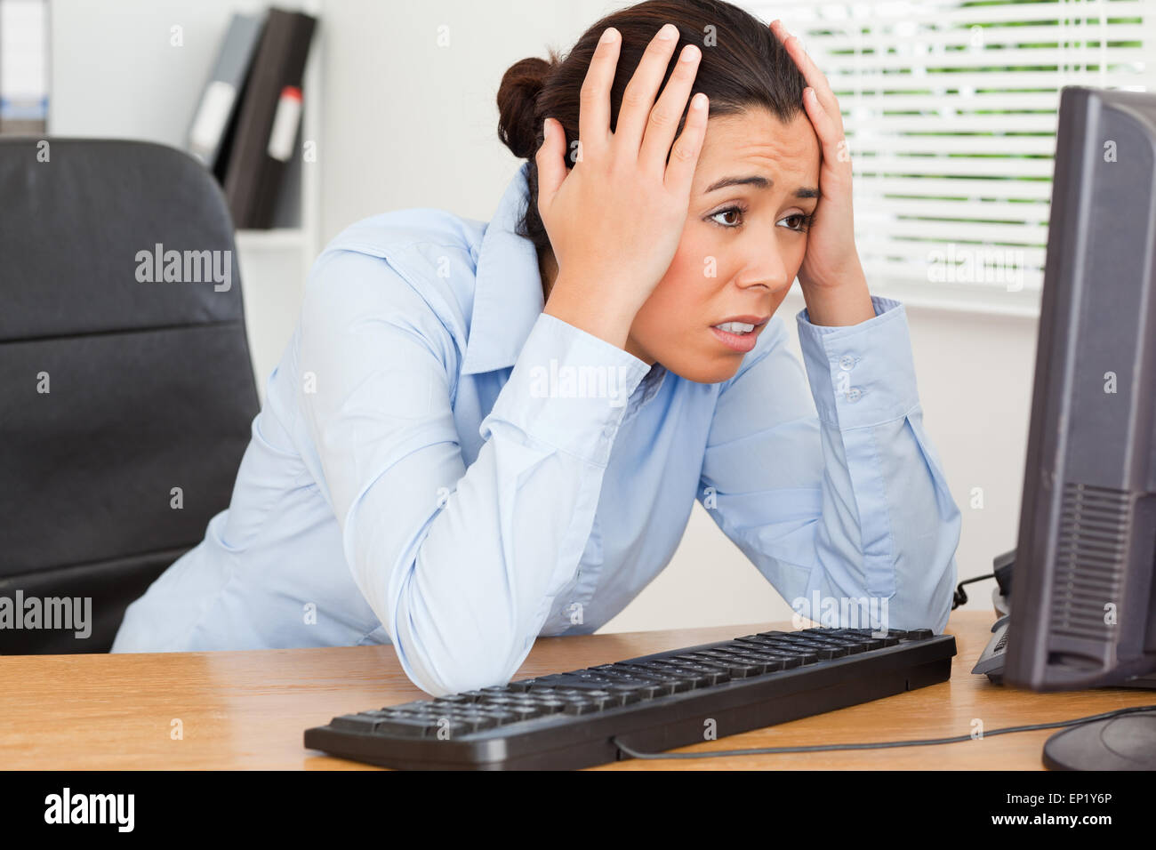 Good looking upset woman looking at a computer screen while sitting ...