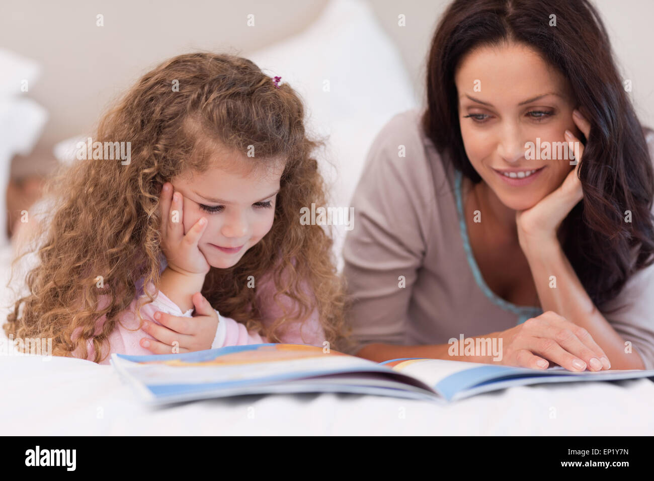 Little girl reading bedtime story with her mother Stock Photo - Alamy