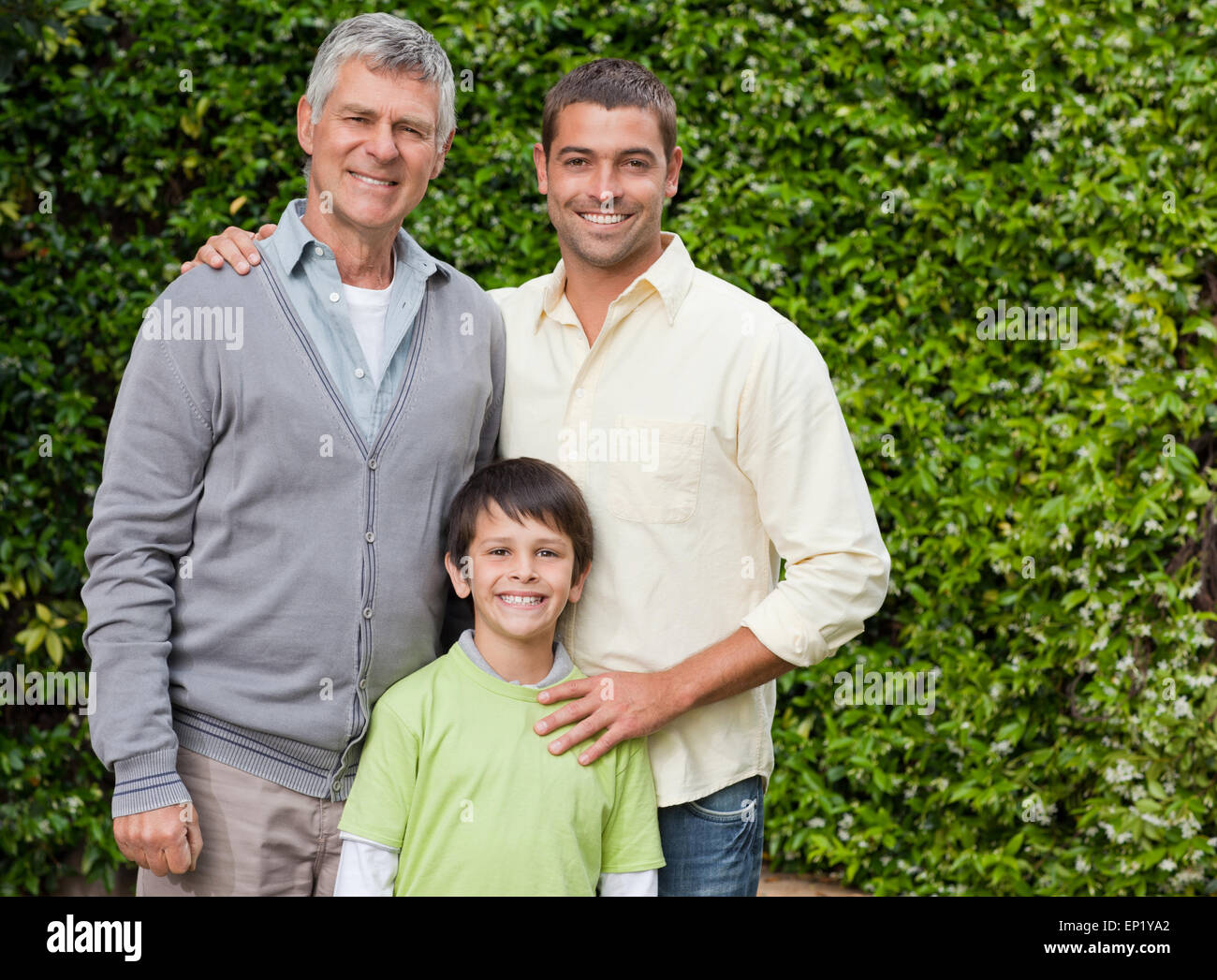 Radiant family looking at the camera in the garden Stock Photo - Alamy