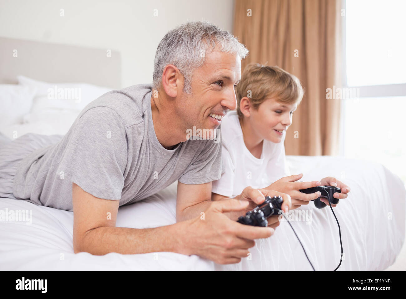 Smiling father and his son playing video games Stock Photo - Alamy
