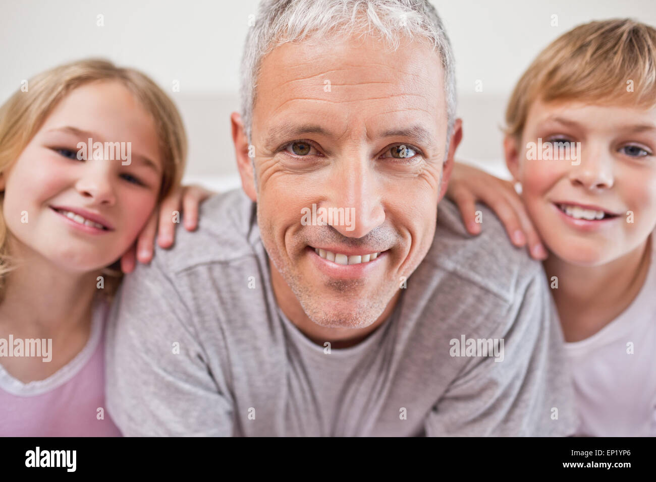Close up of siblings and their father posing Stock Photo - Alamy