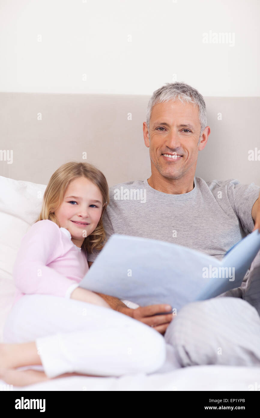Portrait of a father reading a story to his daughter Stock Photo - Alamy