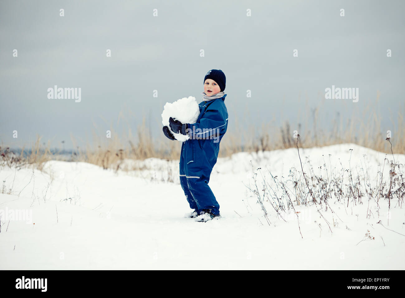Boy holding giant snowball hi-res stock photography and images - Alamy